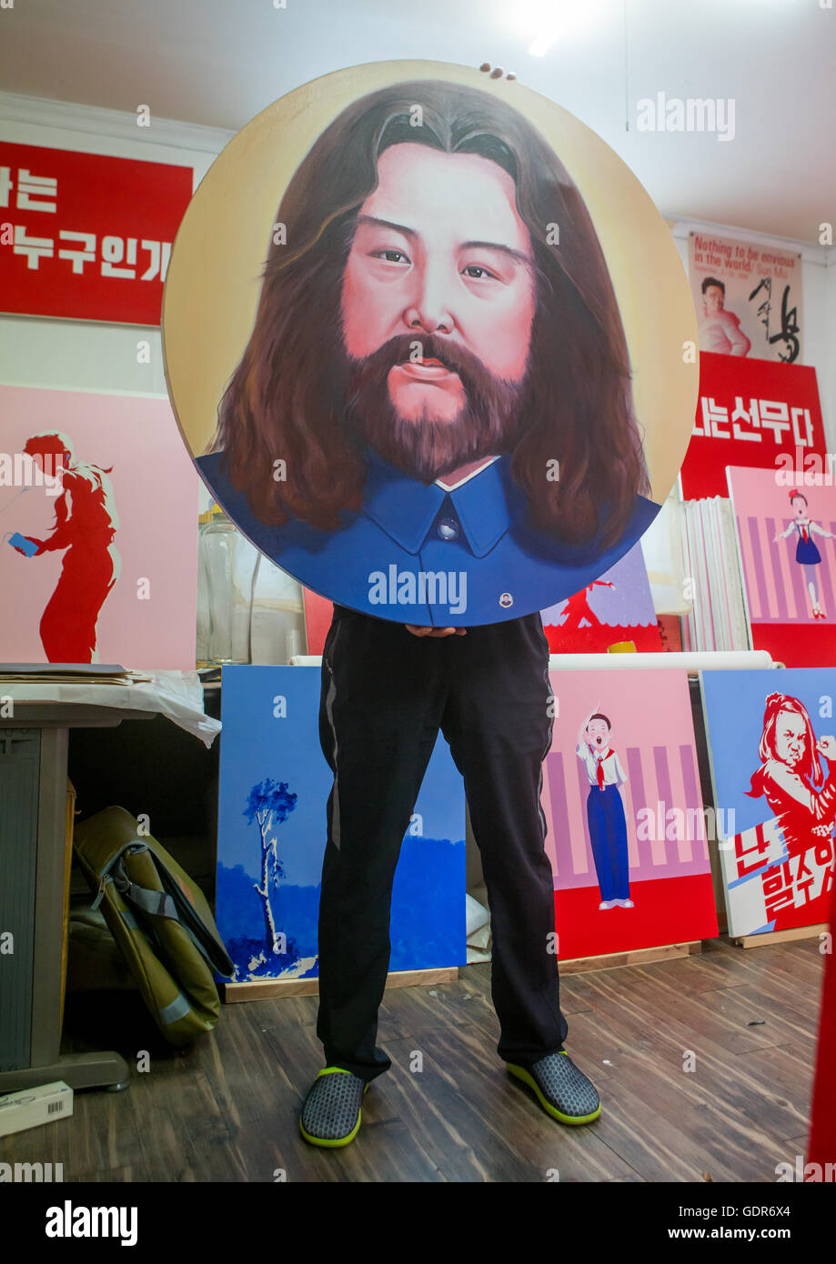 Sun mu artist hiding behind a painting of kim jong il looking like ...