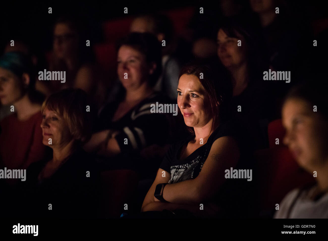 Girl in the audience smiling while watching performance in the theater ...
