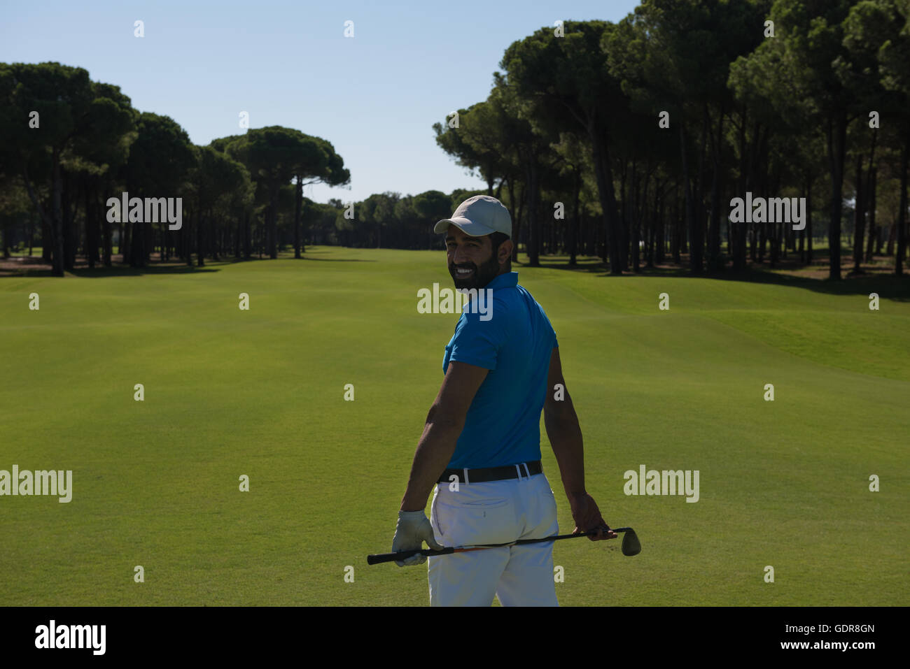 handsome middle eastern golf player portrait from back with course in ...