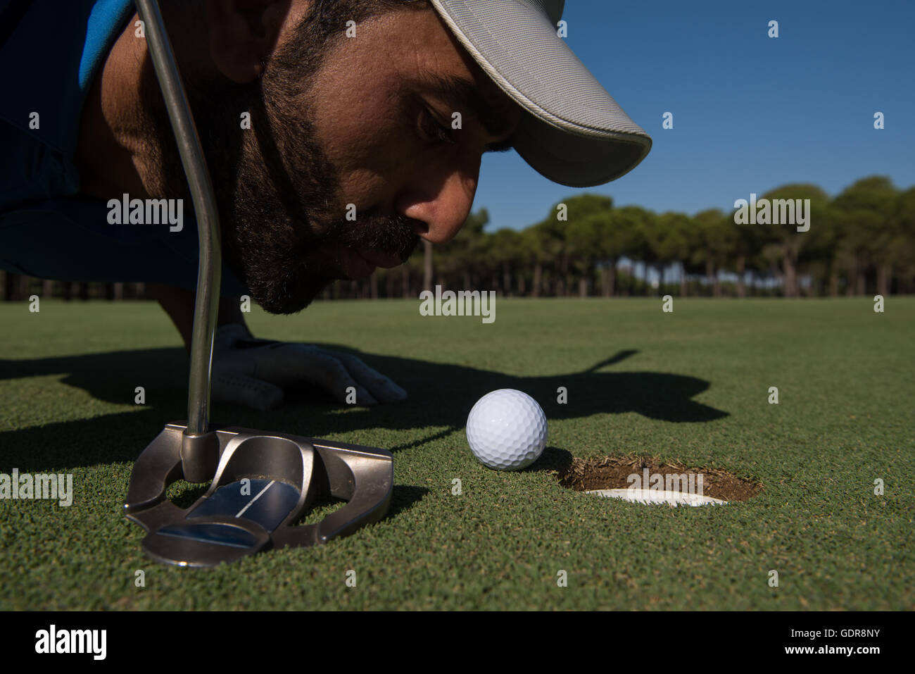 golf player blowing ball in hole. concept of cheating and success Stock ...