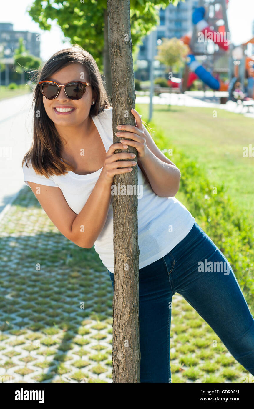 Beautiful girl having fun and playing around outside in park wearing ...