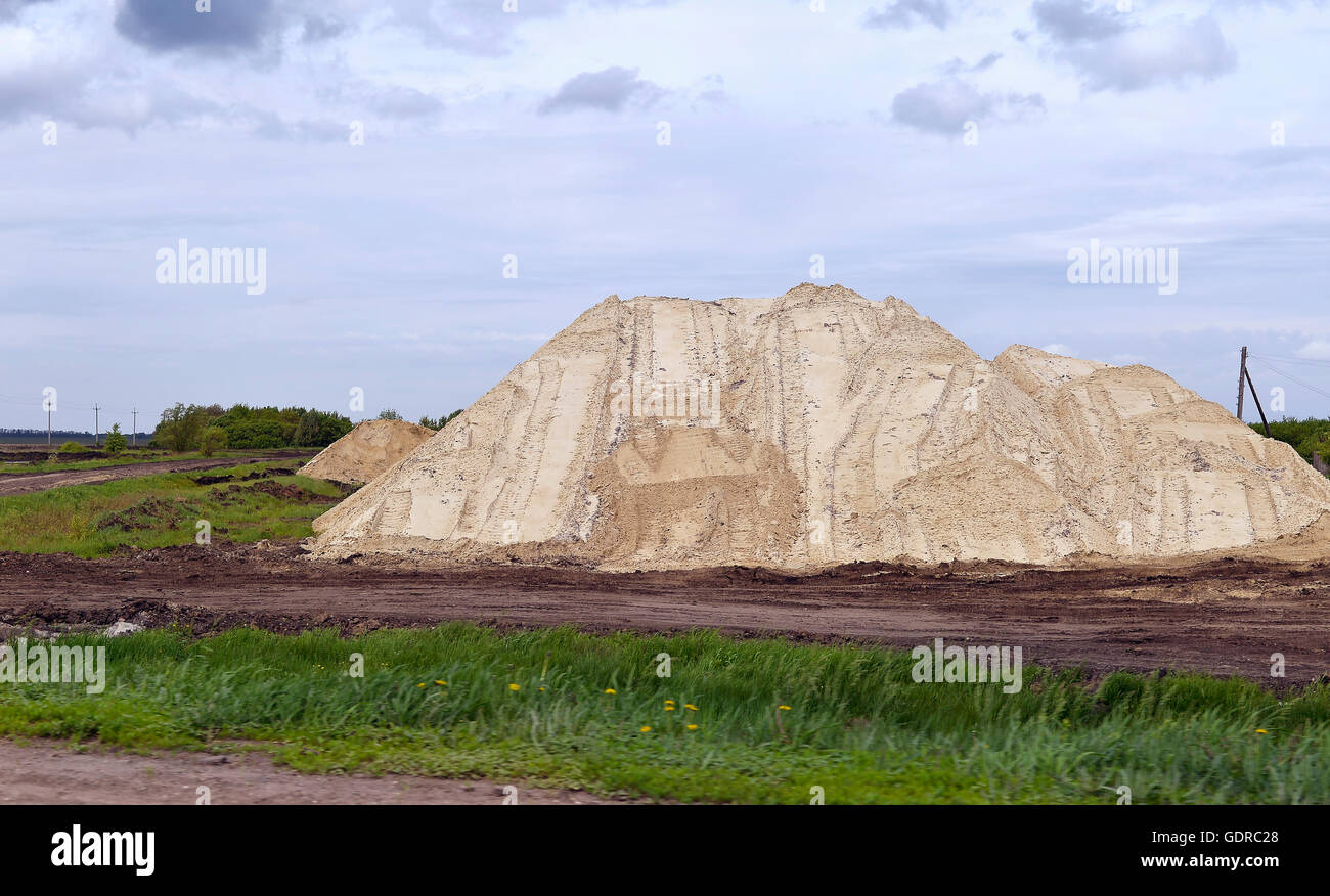 Yellow excavator working digging in sand quarry Stock Photo - Alamy
