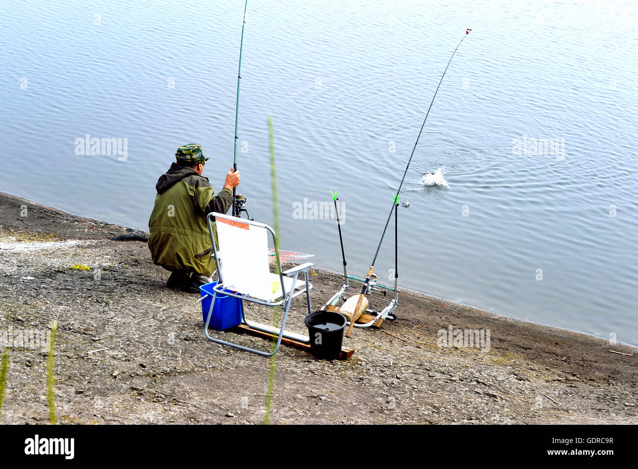 A fisherman with a fishing rod on the river bank Stock Photo - Alamy