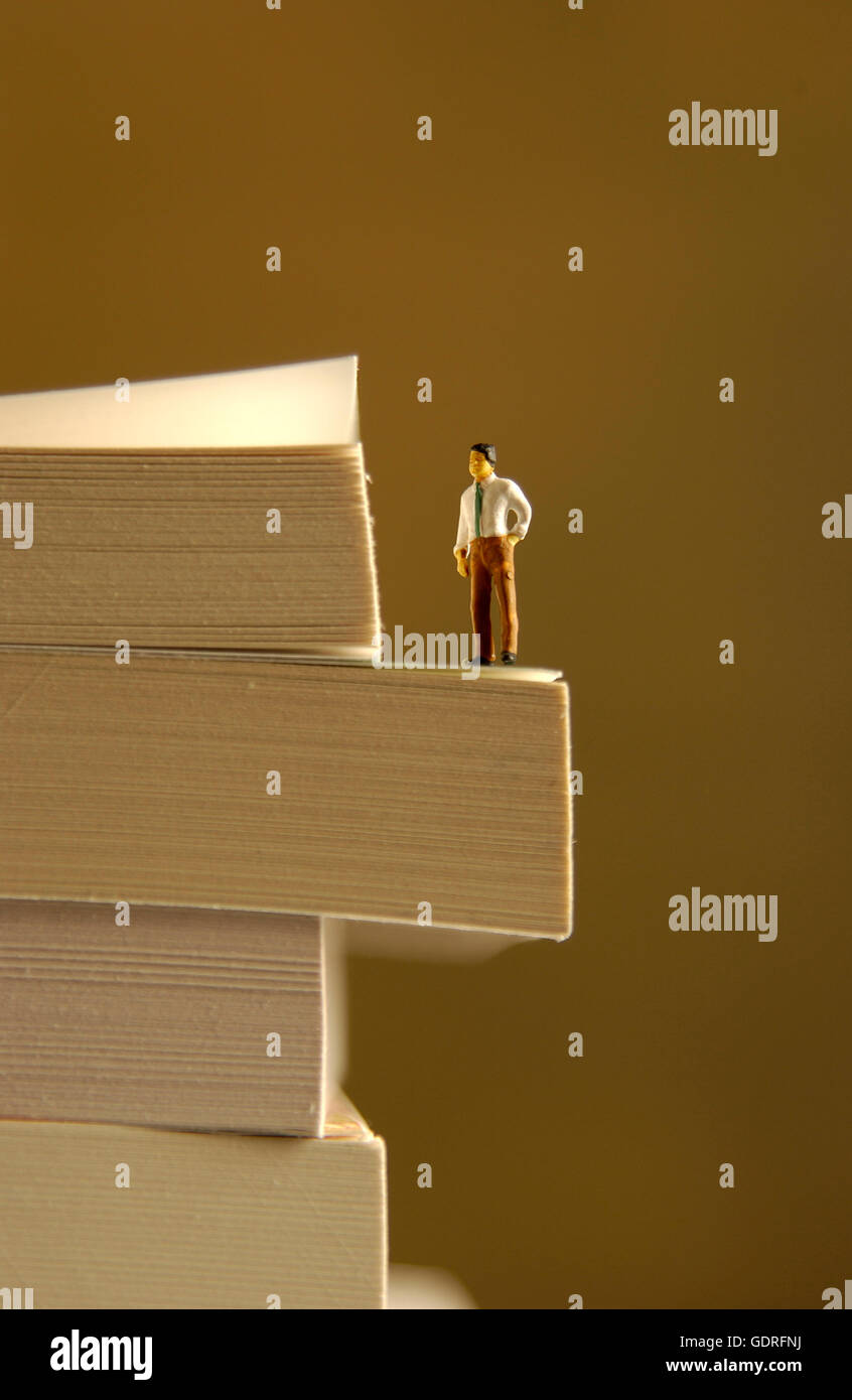 Figurine on pile of books Stock Photo - Alamy