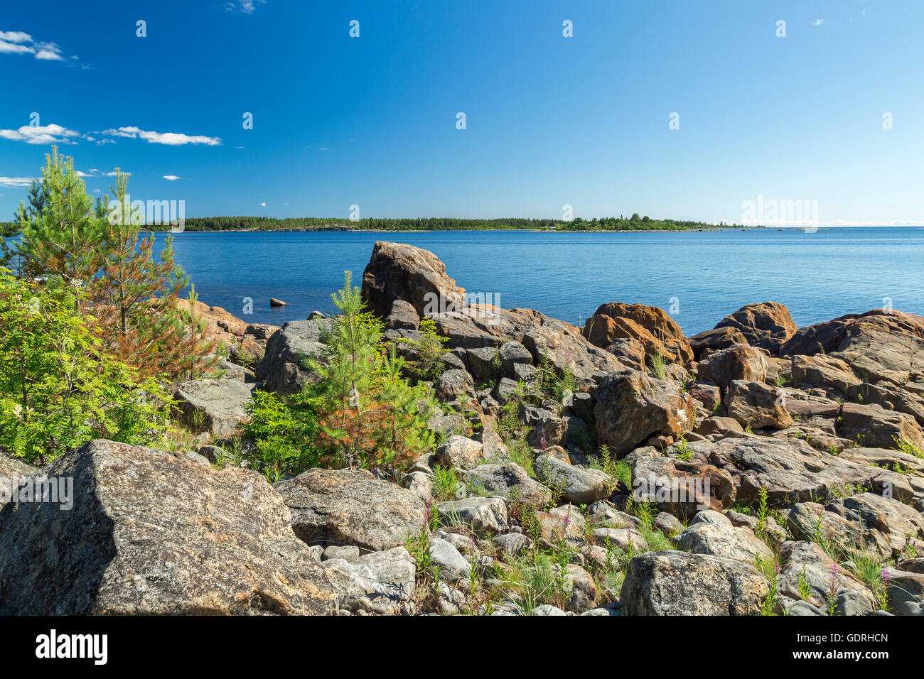 Rocks By Ocean with island in the distance Stock Photo - Alamy