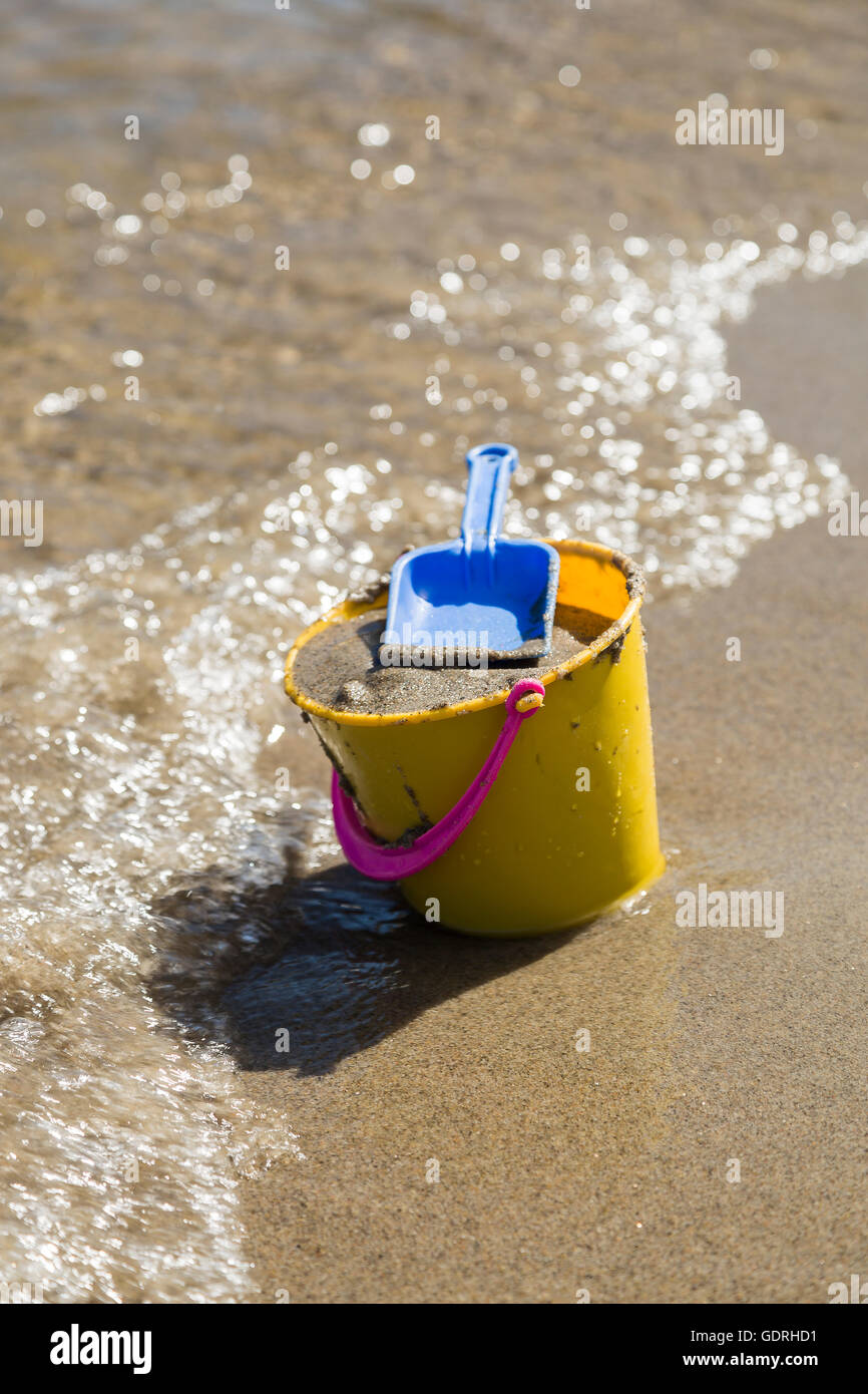 Toy Spade and Bucket on a Beach Shore Stock Photo - Alamy