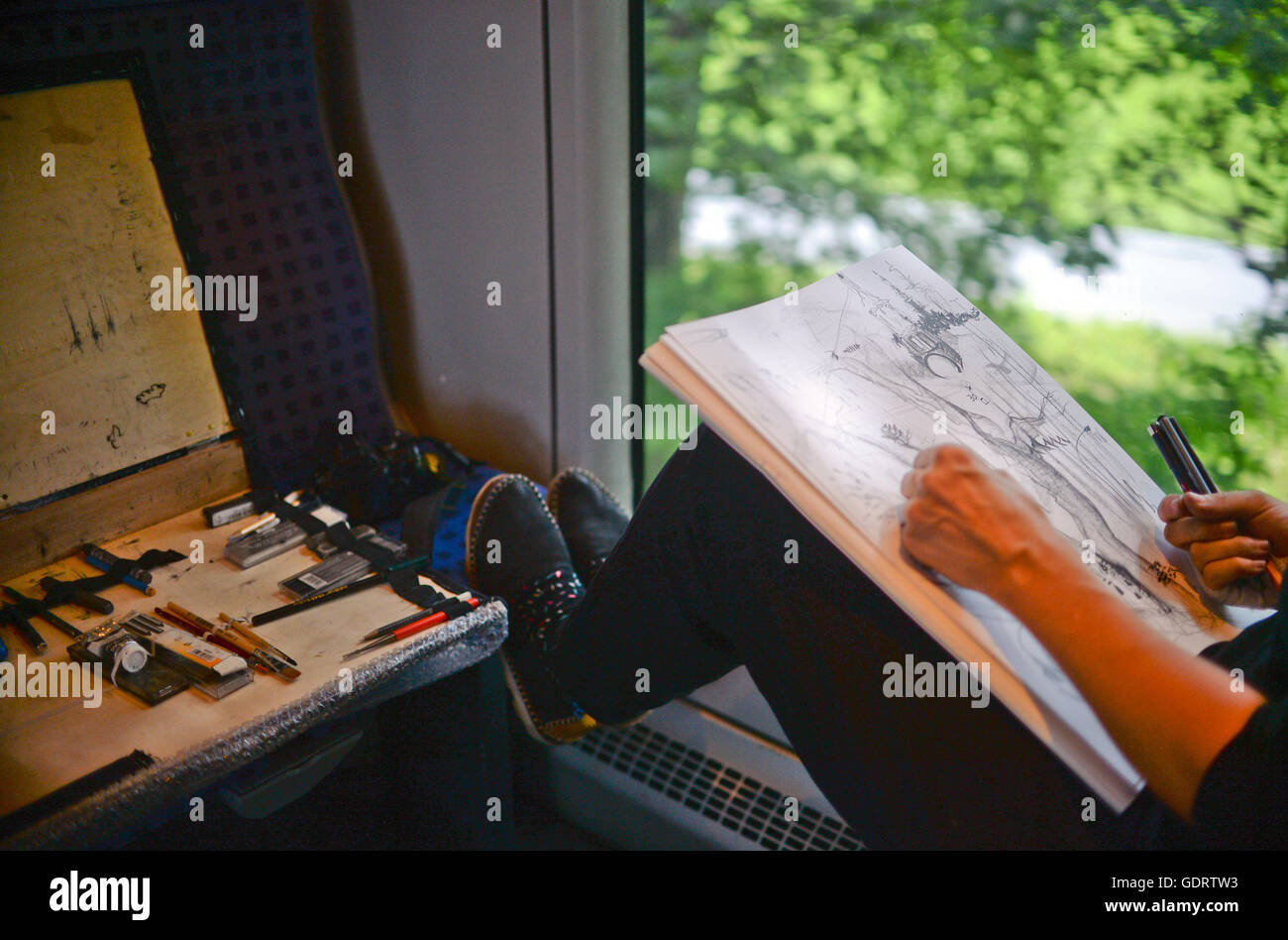 Artist Christine Wacker works on a drawing as she sits in the 'Kunstzug ...