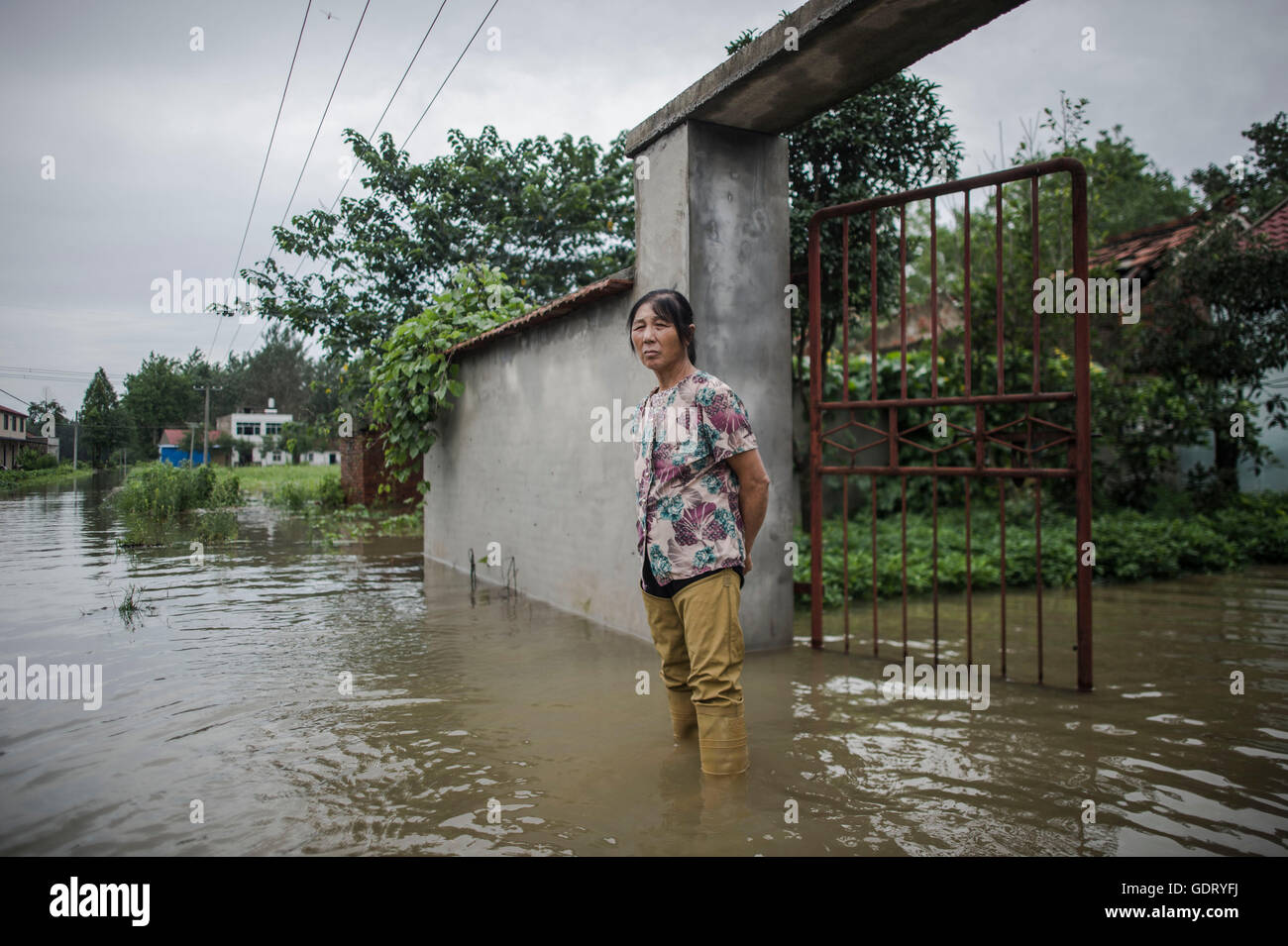 Shayang, China's Hubei Province. 20th July, 2016. A villager stands in ...