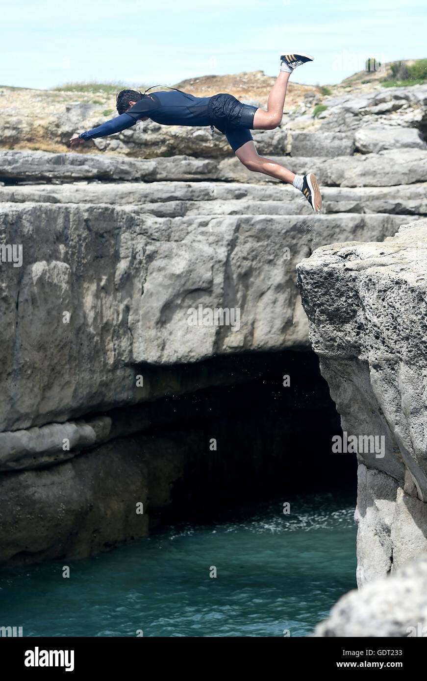 Youngsters cool off by tombstoning off the rocks at Portland Bill ...
