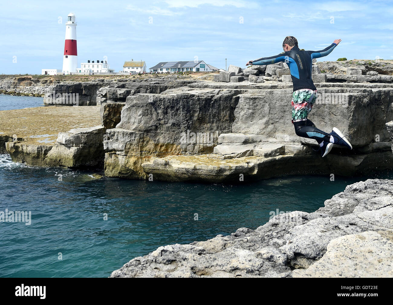 Youngsters cool off by tombstoning off the rocks at Portland Bill ...