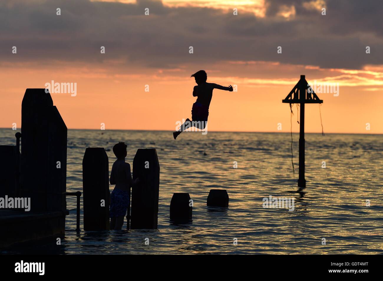 Boy jumping off pier hi-res stock photography and images - Alamy
