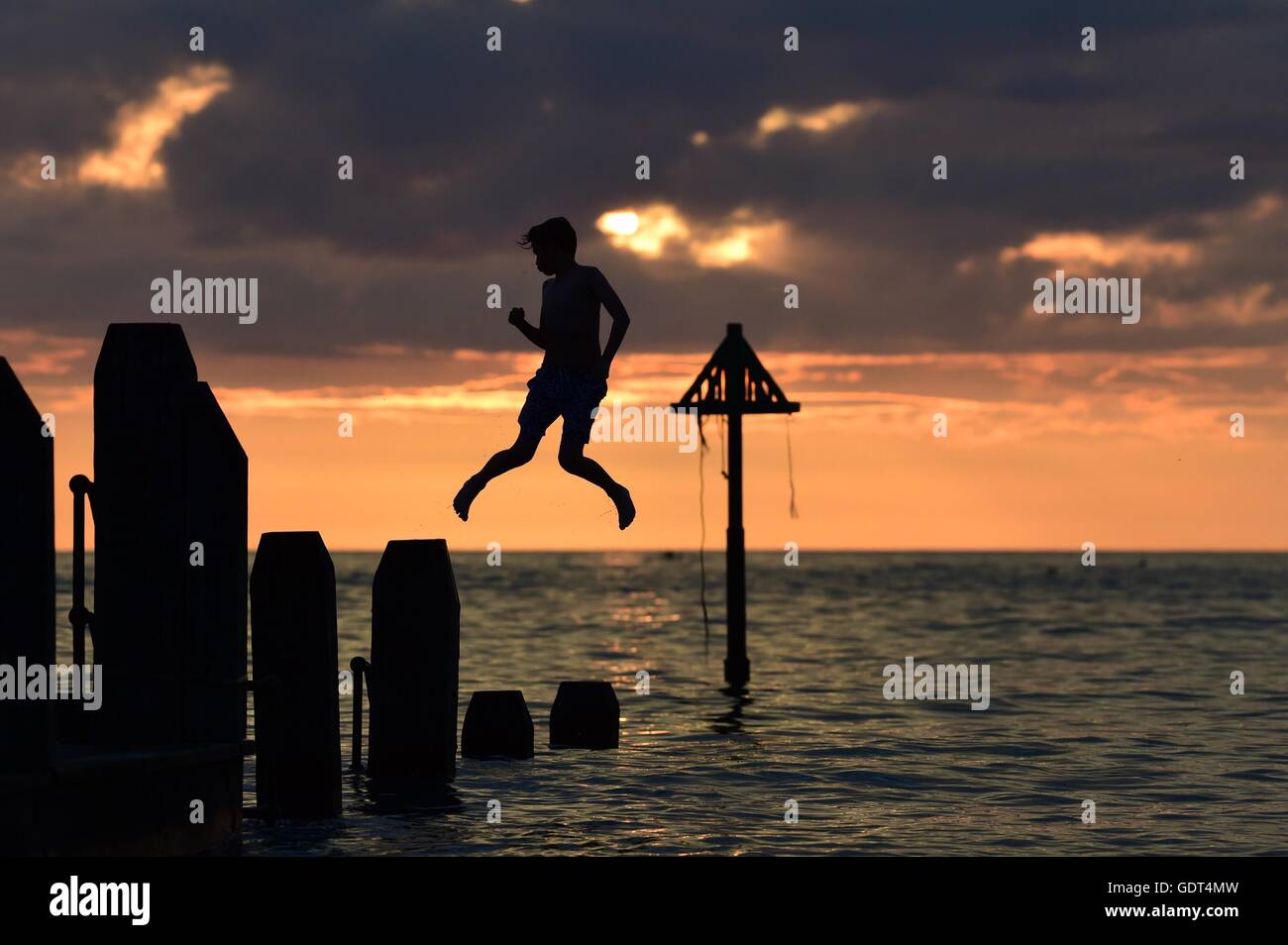Boy jumping off pier hi-res stock photography and images - Alamy