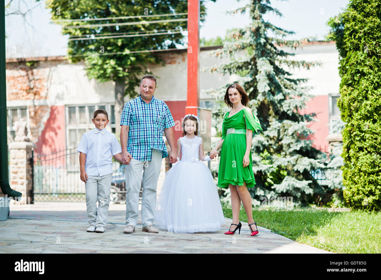 Happy family at first holy communion walking background church cross ...