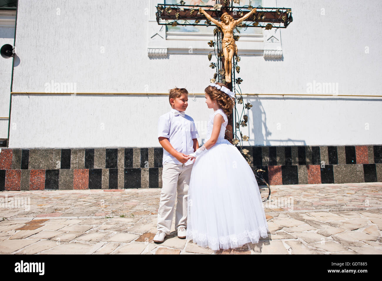 Brother and sister at first holy communion background church cross ...