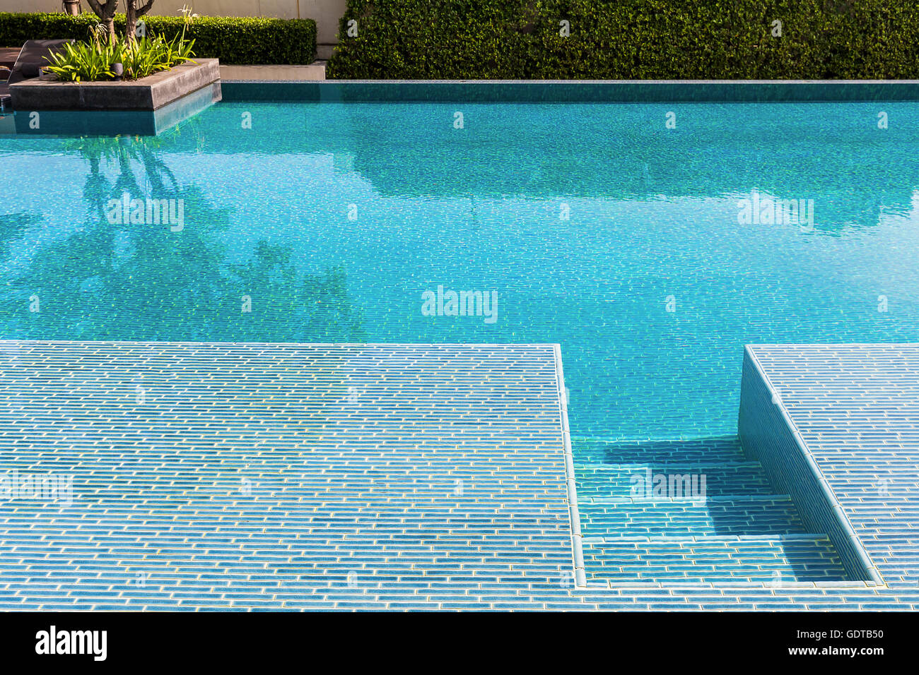 Swimming pool made by mosaic tiles with small stairs inside the clear ...