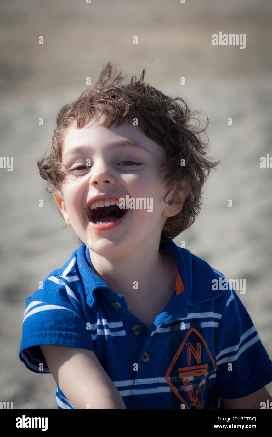 boy playing and smiling at the beach Stock Photo - Alamy
