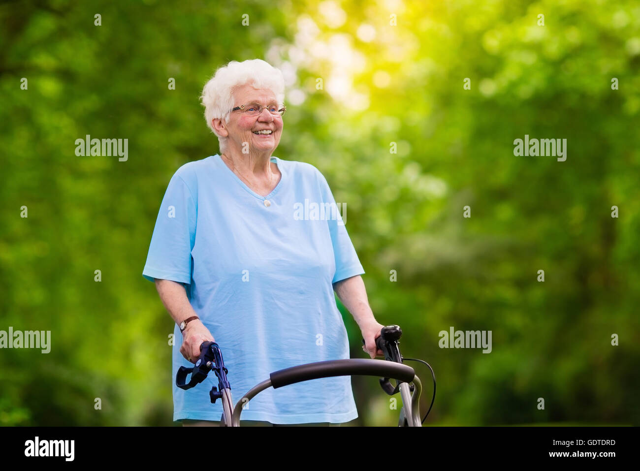 Happy senior handicapped lady with a walking disability enjoying a walk ...
