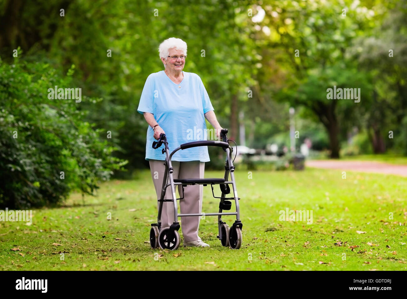 Happy senior handicapped lady with a walking disability enjoying a walk ...