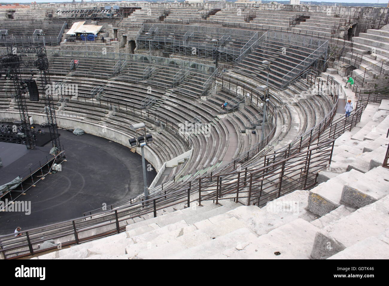 Visitors listening to audio guides at the Roman amphitheatre in Nimes ...