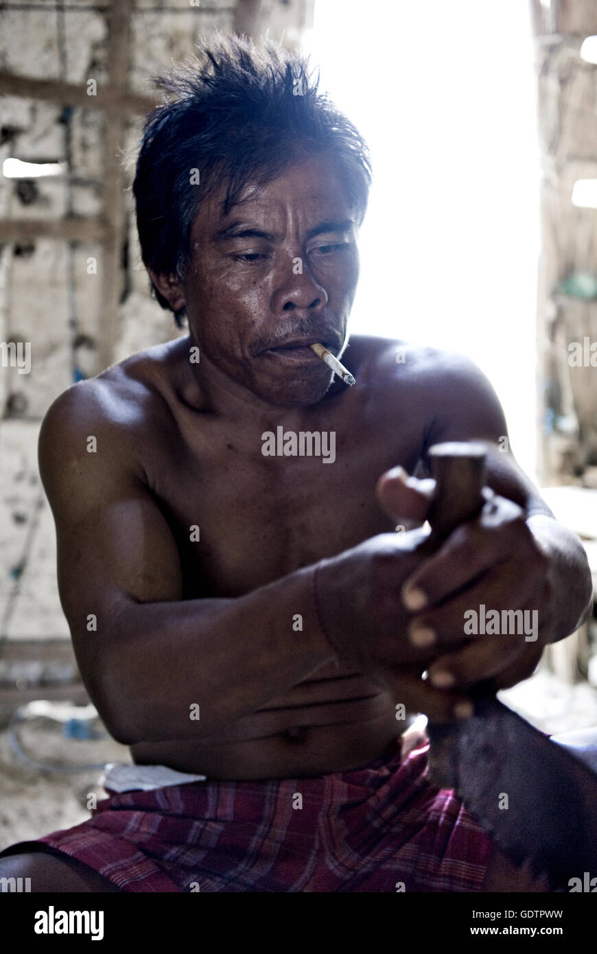 Coral collector cuts up a 'tombong rock' in standard-sized building ...