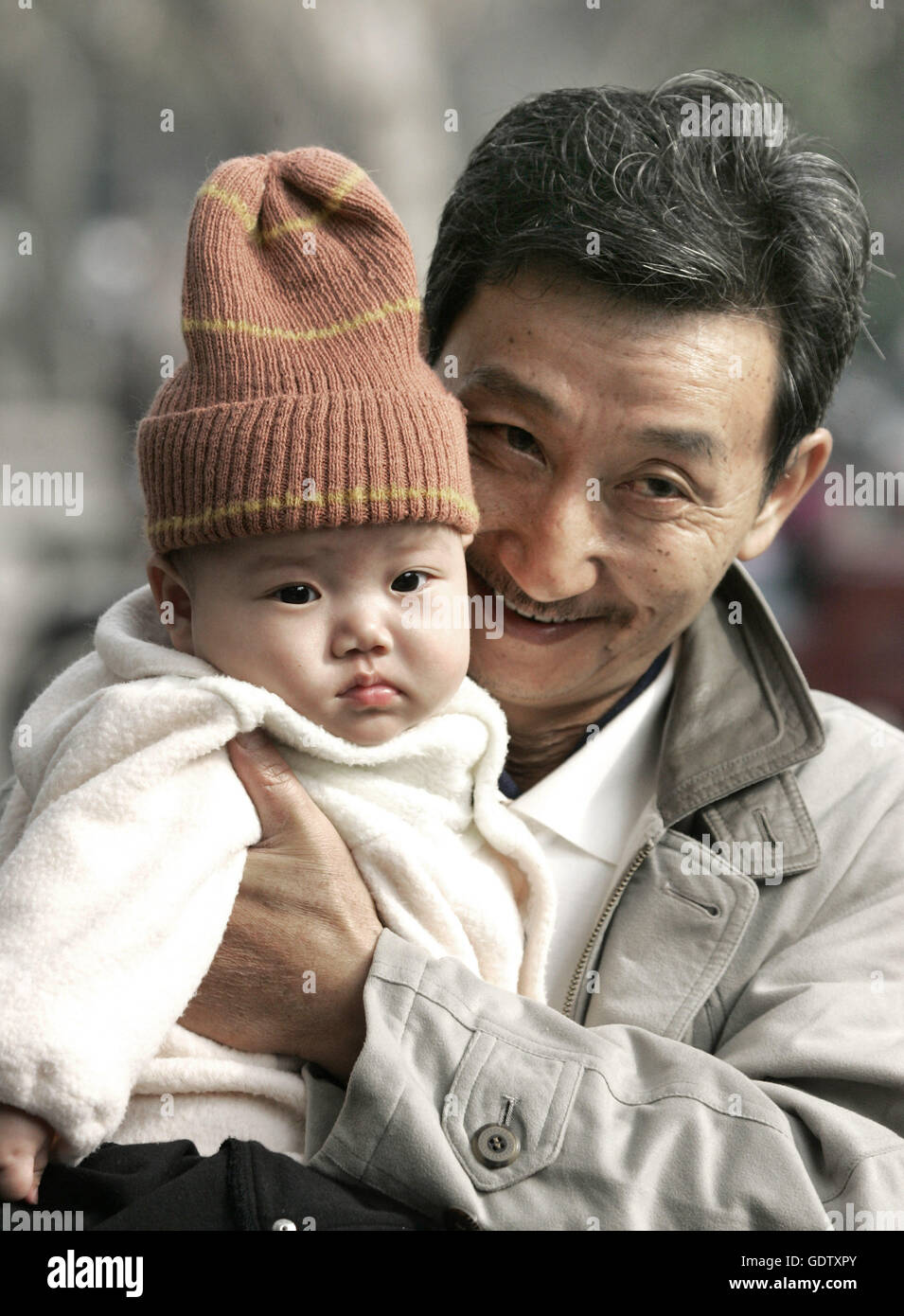16 11 2004 a chinese father holding his baby in his arms hi-res stock ...