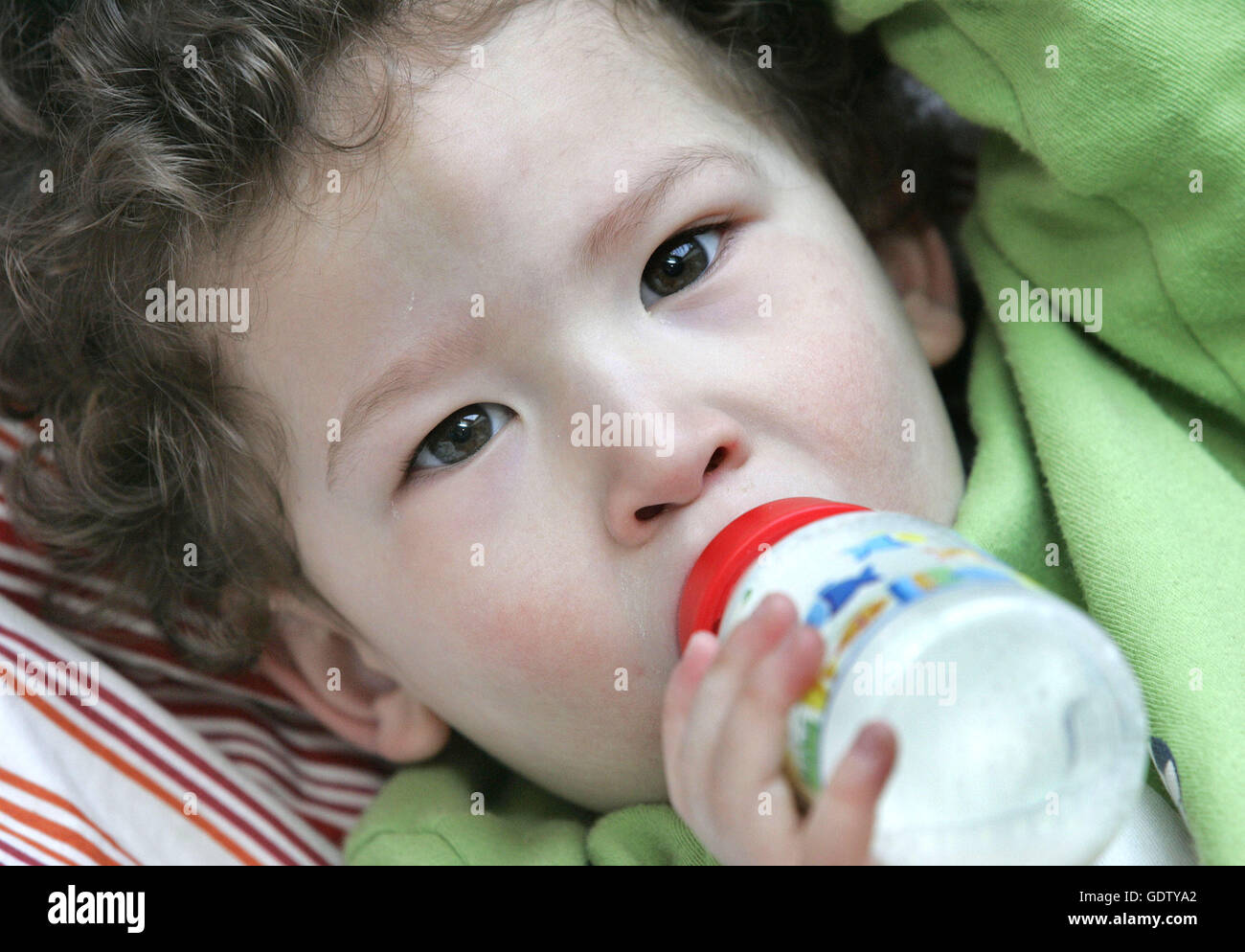 Little boy drinking from baby bottle Stock Photo - Alamy