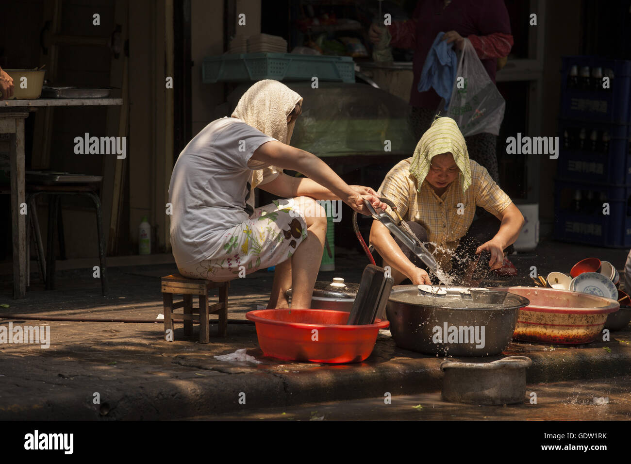 Two women cover their head to block sunlight Stock Photo - Alamy