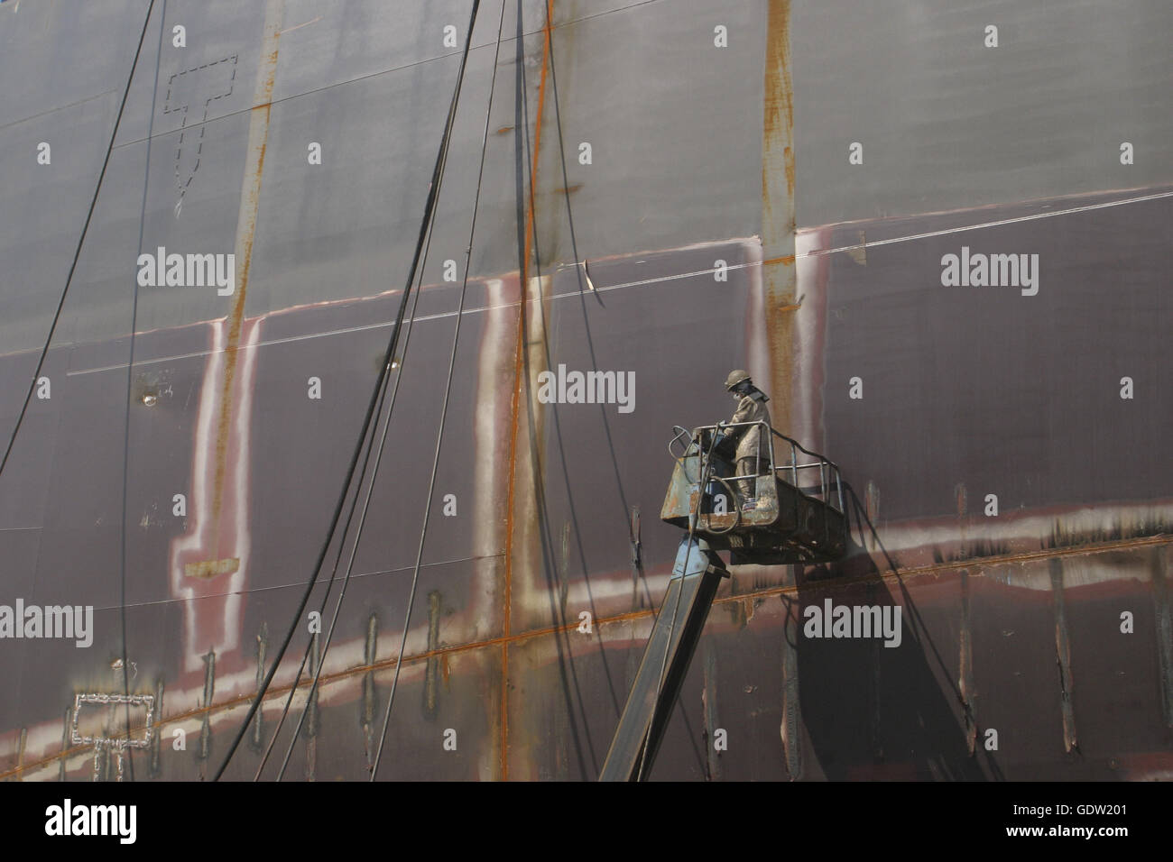 A Chinese welder descends to the working position of a bulk Carrier at ...