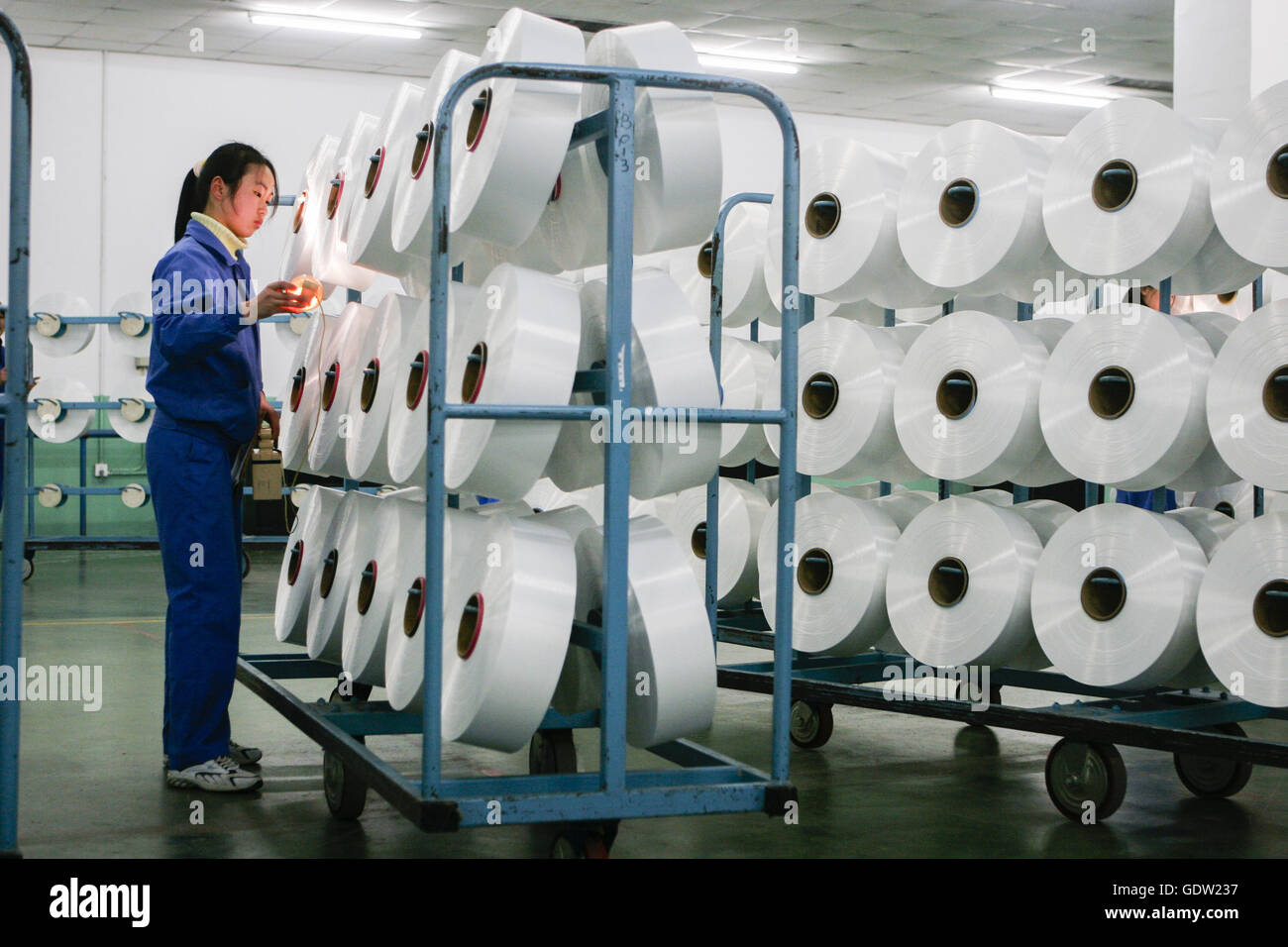A Chinese worker check yarn roll fresh out of the production line at ...