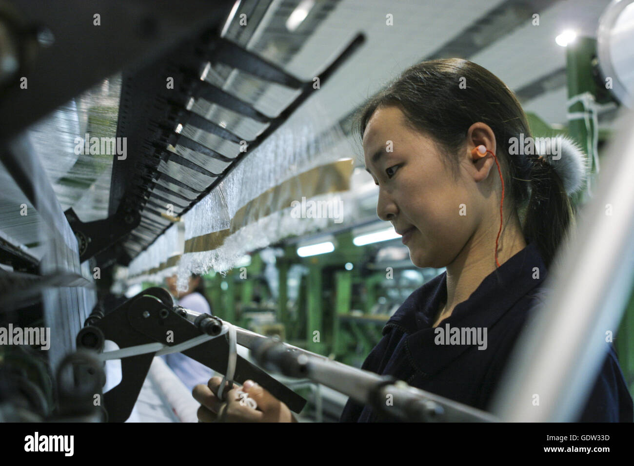 Factory workers handle yarn on a knitting machine december 10 hi-res ...