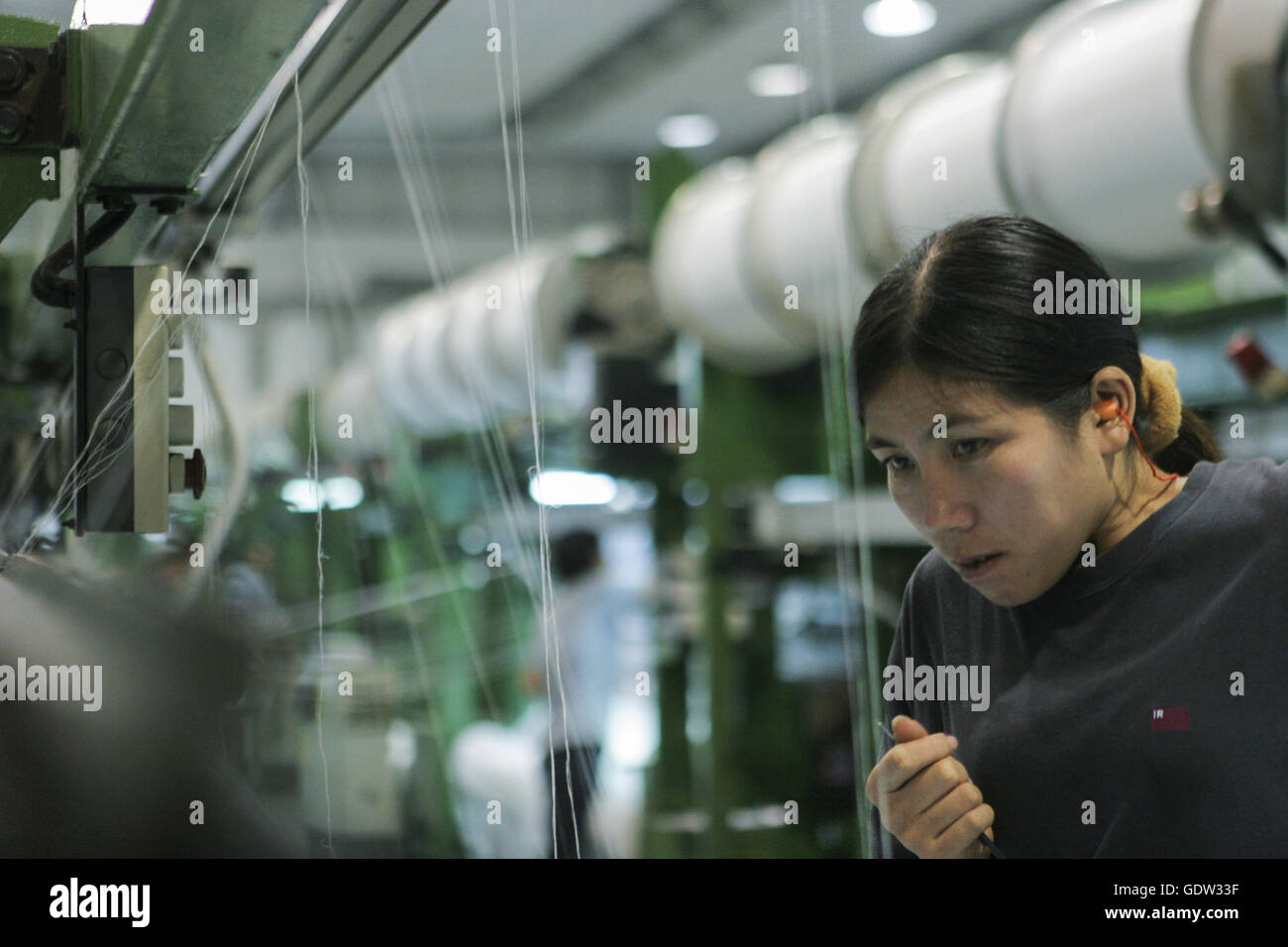 Factory workers handle yarn on a knitting machine December 10 Stock ...