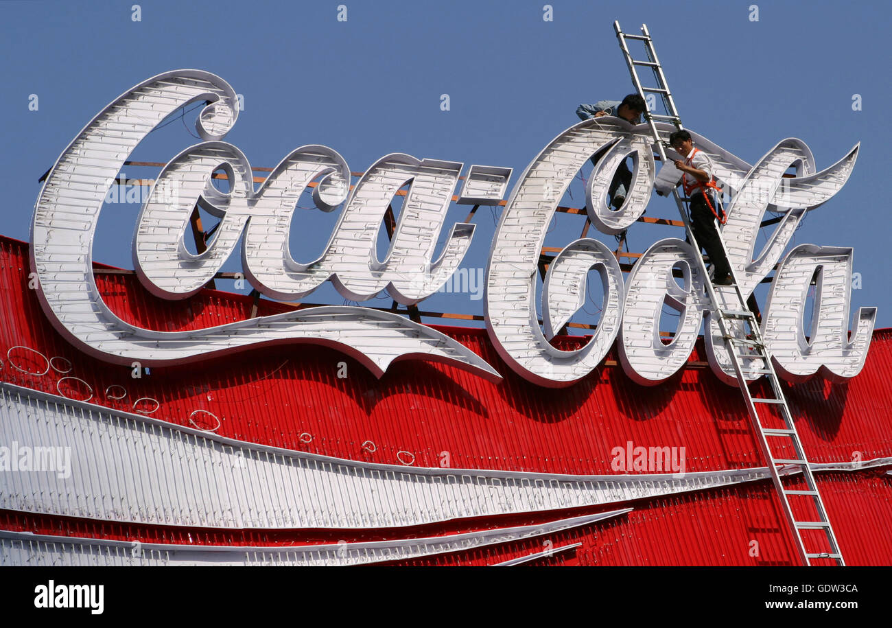 Workers set up coca cola sign on top of building hi-res stock ...