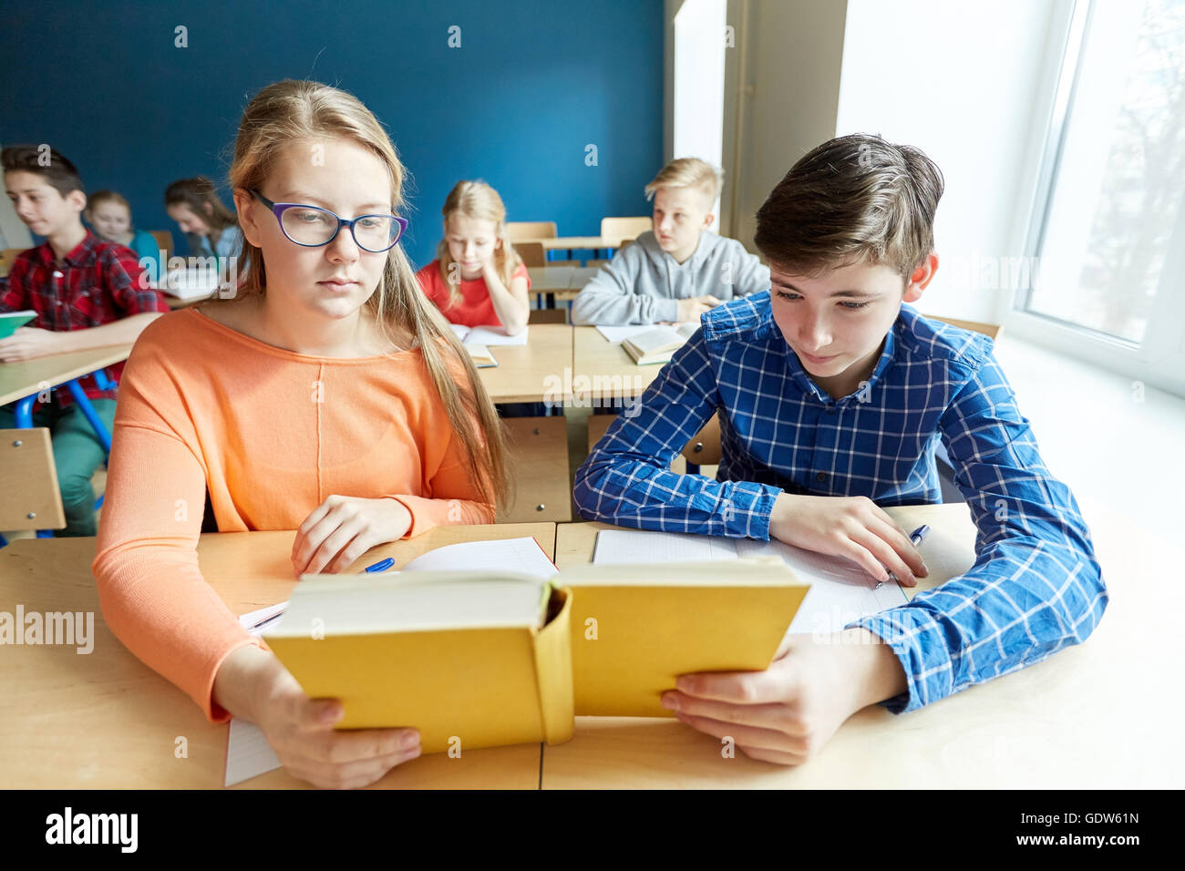 students reading book at school lesson Stock Photo - Alamy