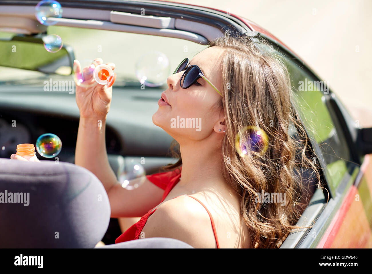 woman blowing bubbles in convertible car Stock Photo - Alamy