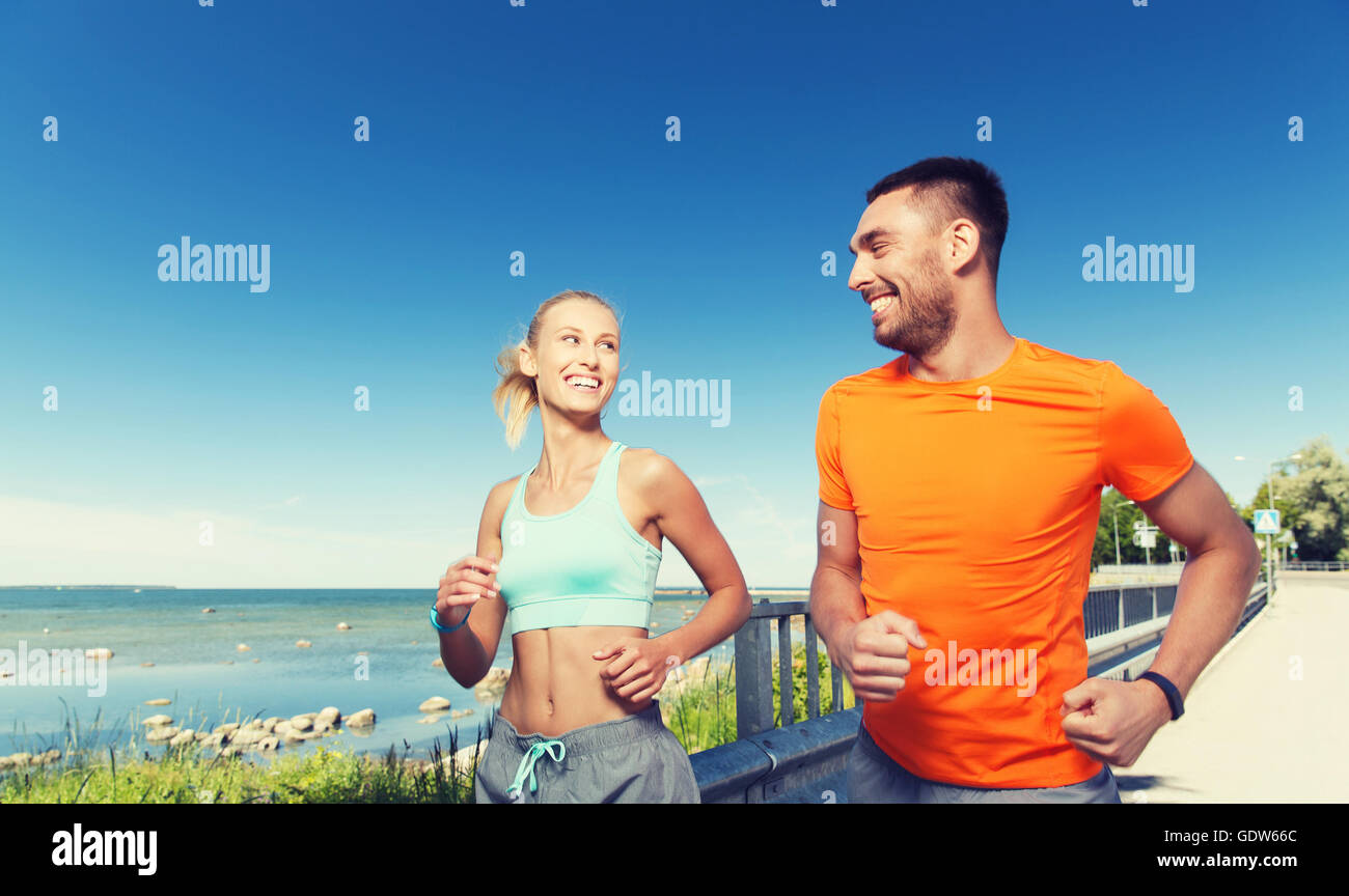 smiling couple running at summer seaside Stock Photo - Alamy