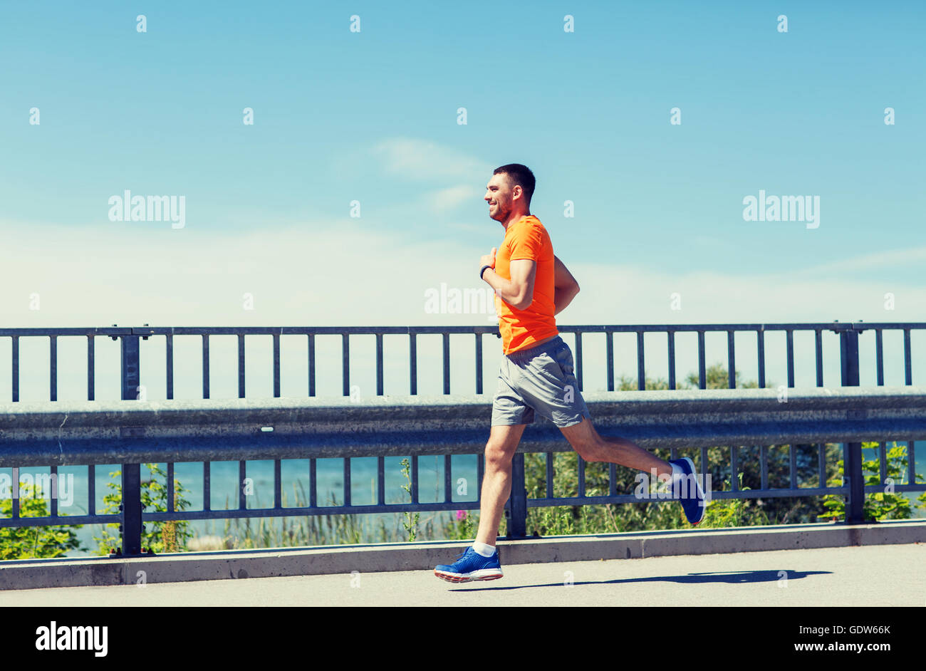 smiling young man running at summer seaside Stock Photo - Alamy