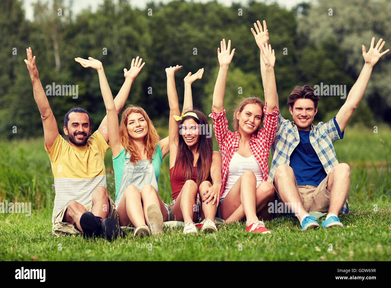 group of smiling friends waving hands outdoors Stock Photo - Alamy