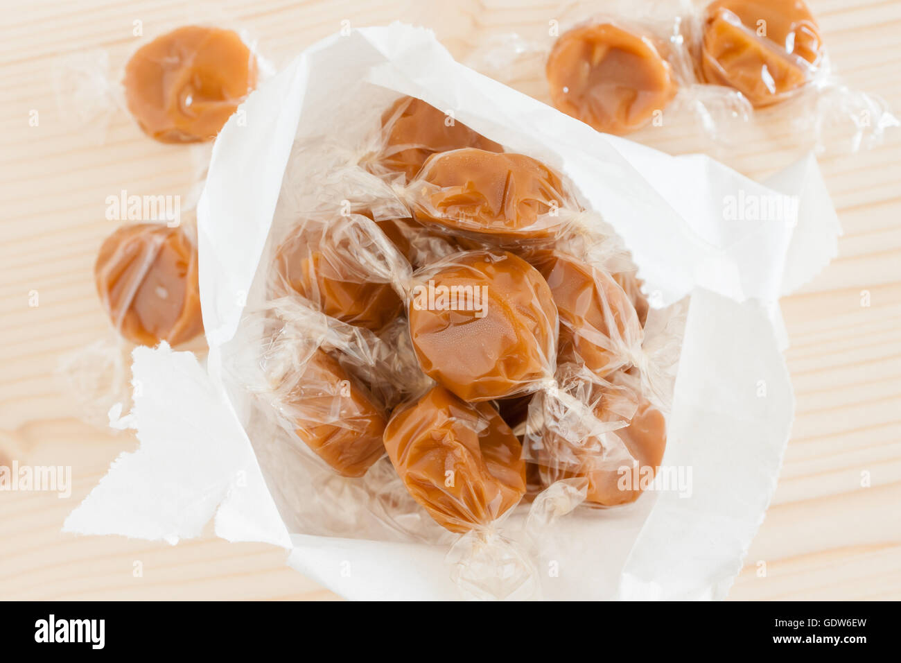 Wrapped toffee pieces in a paper sweet bag top down view Stock Photo ...