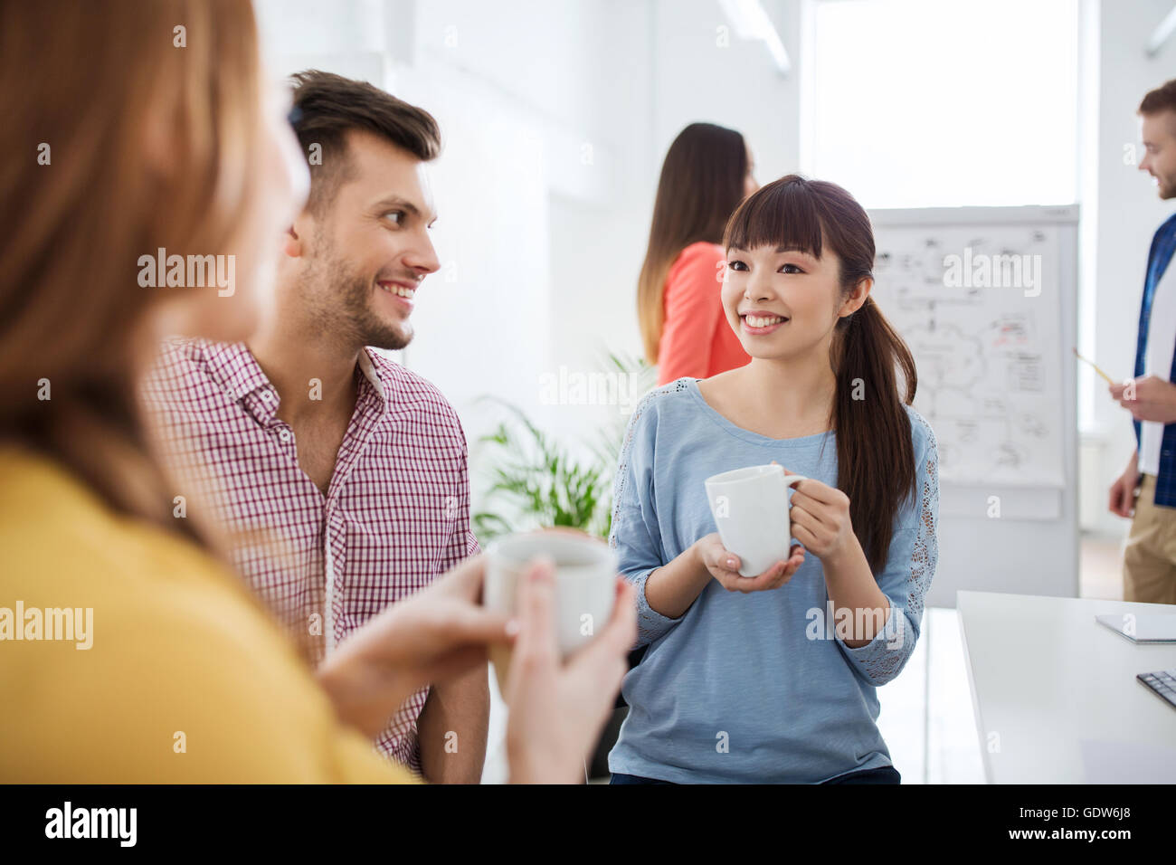 happy creative team drinking coffee at office Stock Photo - Alamy