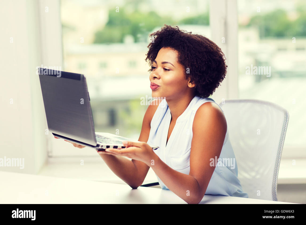 african woman sending kiss to laptop computer Stock Photo - Alamy