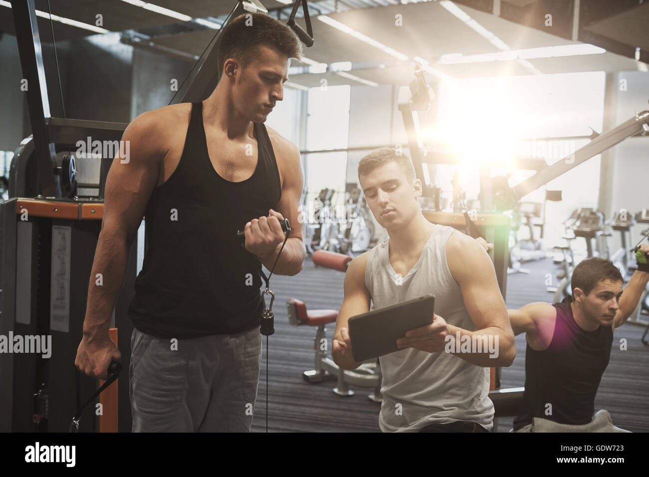 men exercising on gym machine Stock Photo - Alamy