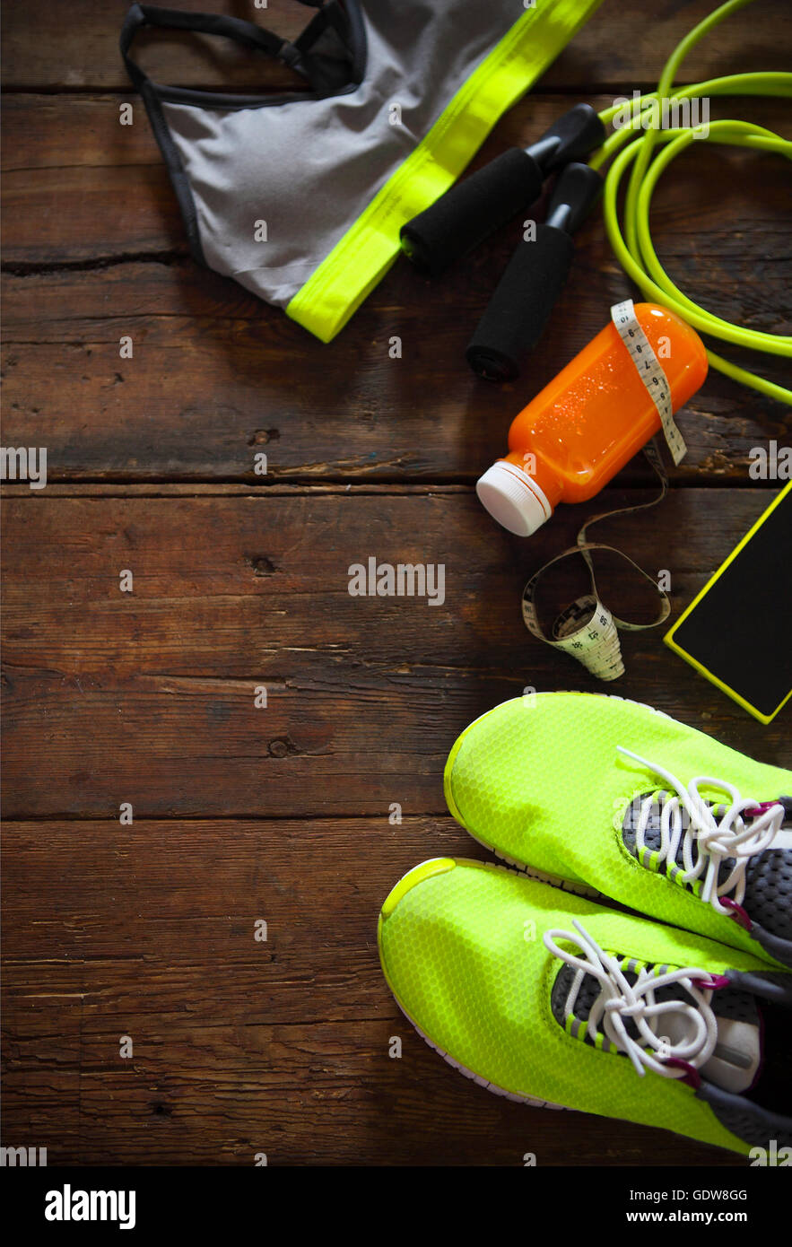 Female sport equipment on a wooden background. Sports items: sneakers ...
