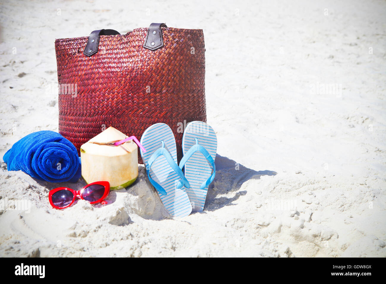 Flip flops, sunglasses, beach towel with beach bag and coconut cocktail ...