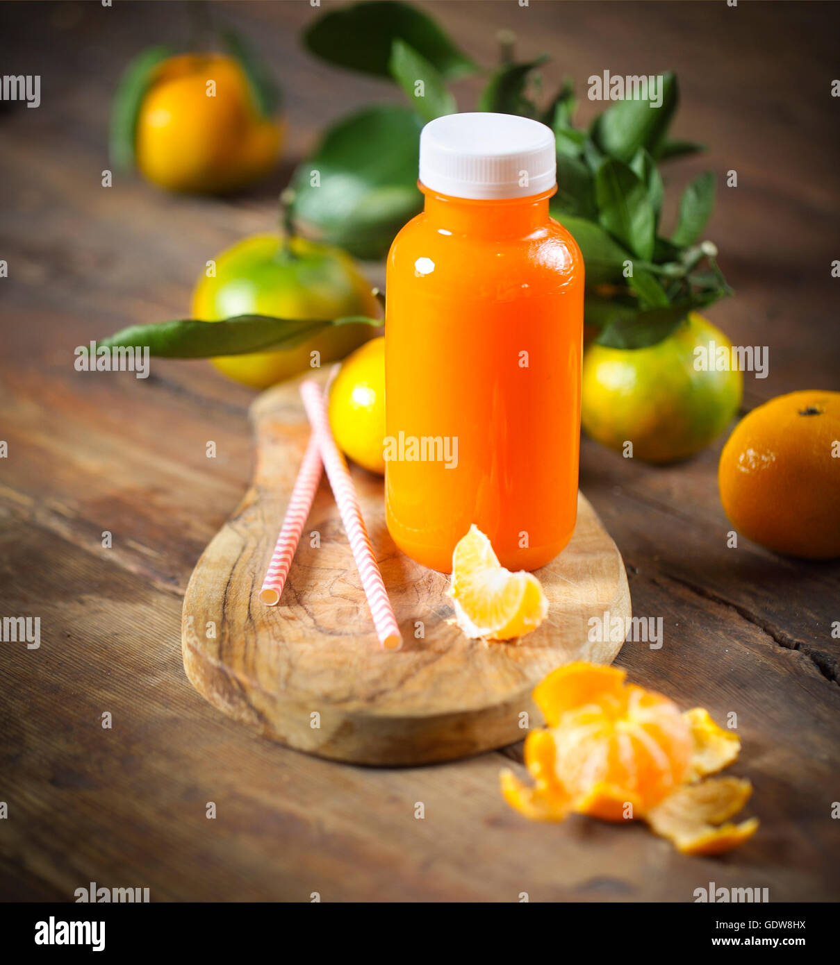 One bottle of fresh tangerine juice with ripe tangerines, leaves and ...