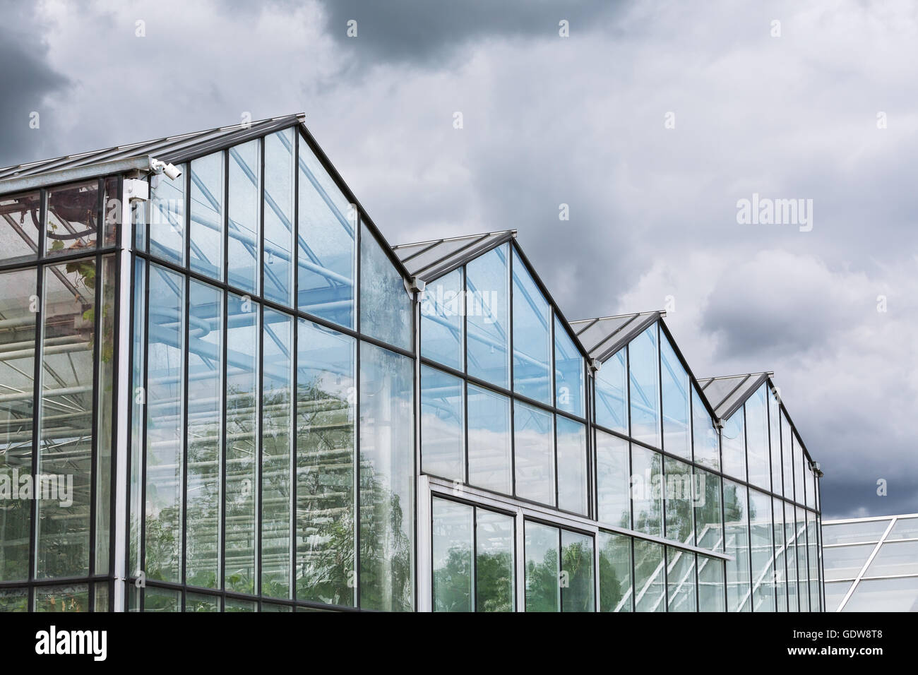 side view of a greenhouse against dark cloudy sky Stock Photo - Alamy