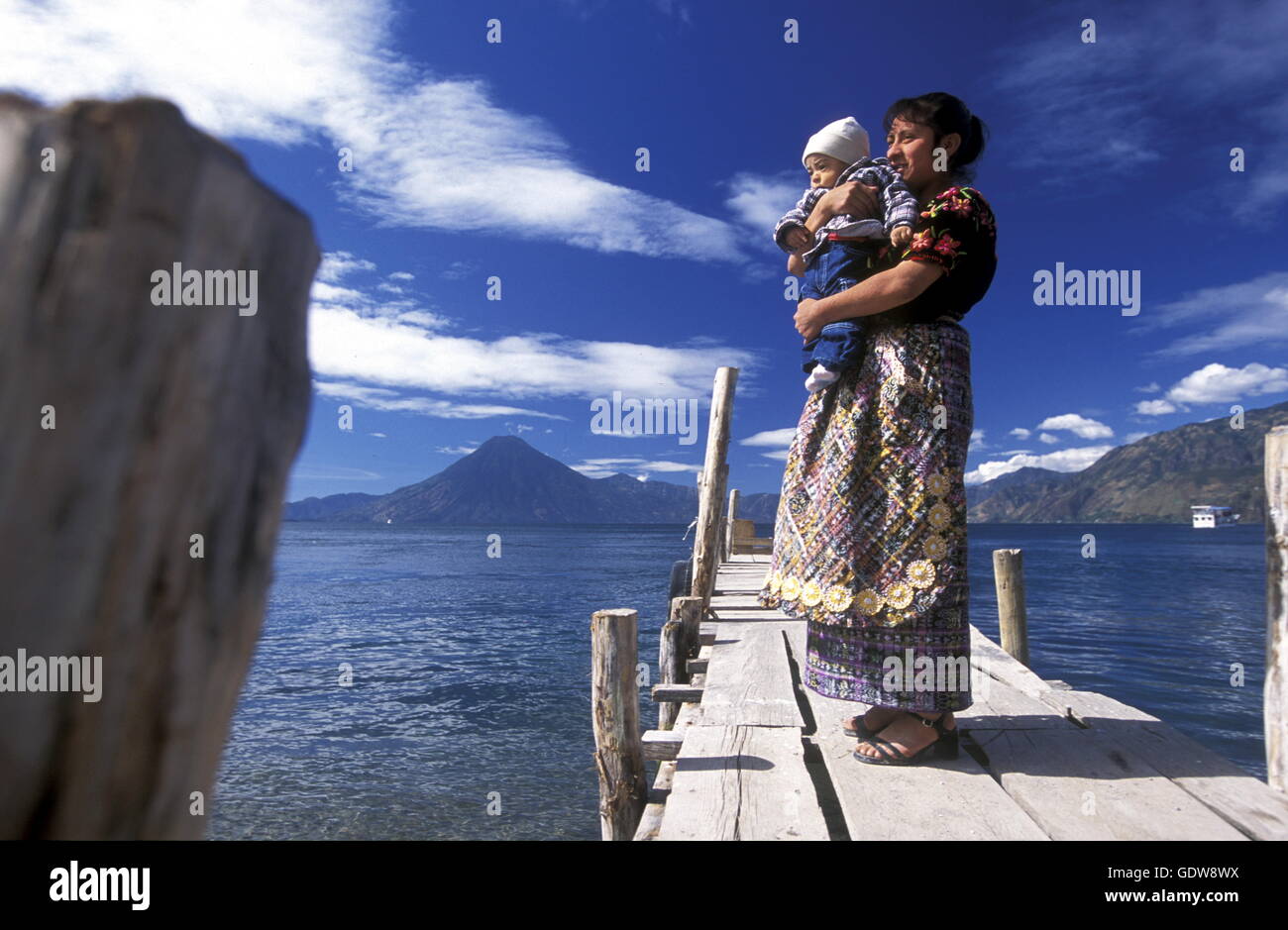 People at the coast of Lake Atitlan mit the Volcanos of Toliman and San ...
