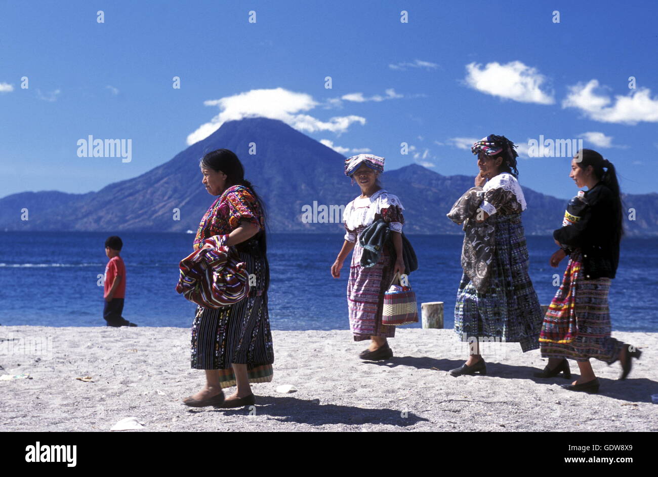People at the coast of Lake Atitlan mit the Volcanos of Toliman and San ...