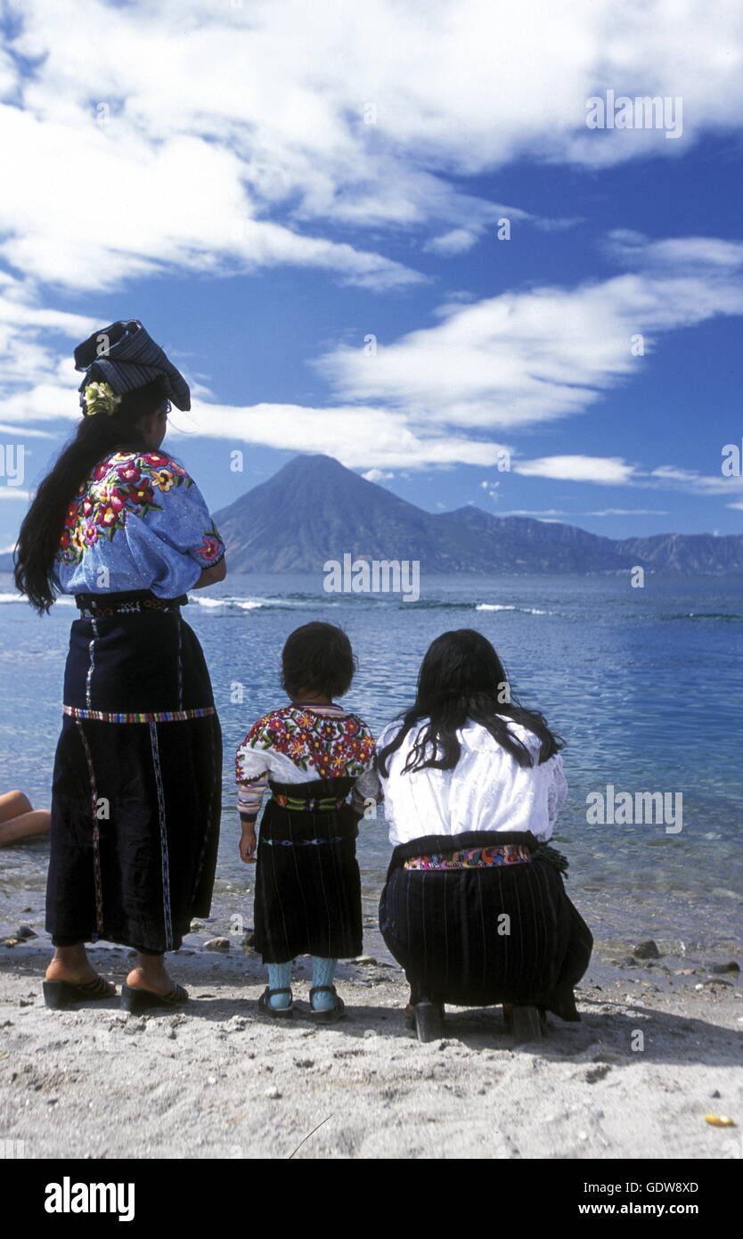 People at the coast of Lake Atitlan mit the Volcanos of Toliman and San ...