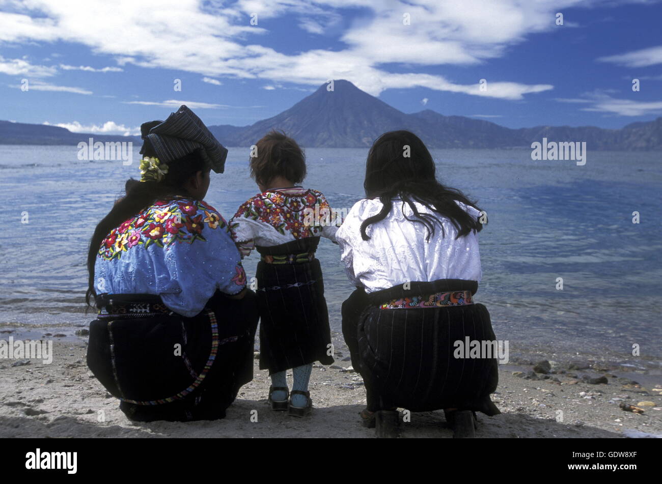 People at the coast of Lake Atitlan mit the Volcanos of Toliman and San ...