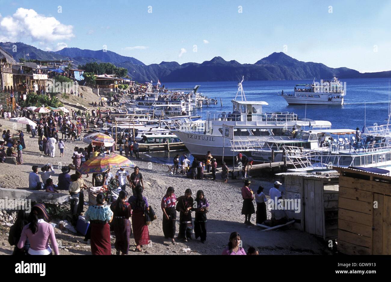 People at the coast of Lake Atitlan mit the Volcanos of Toliman and San ...